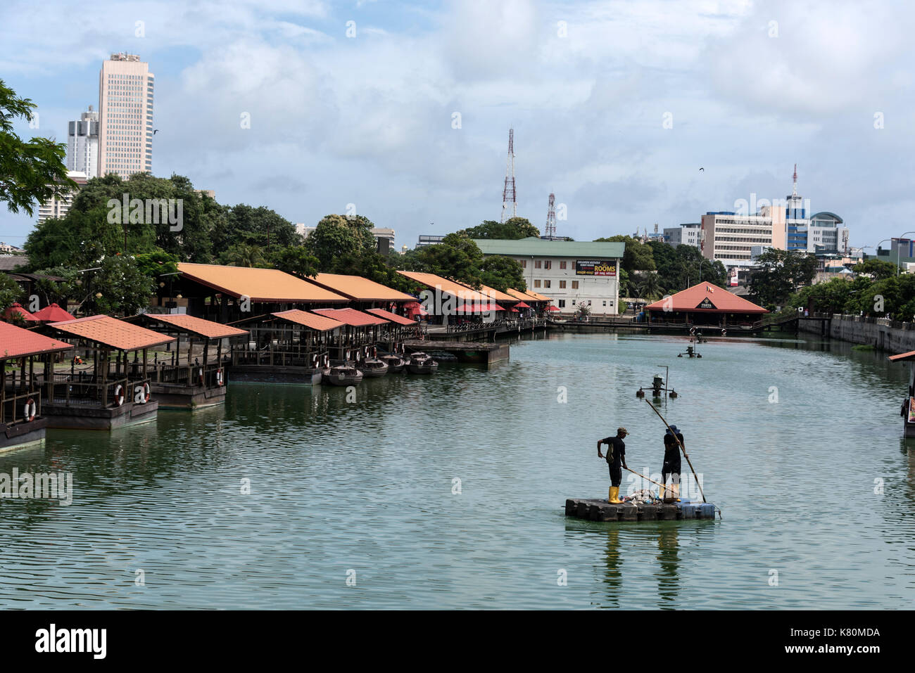 A couple of refuse collection workers on board their basic floating ...