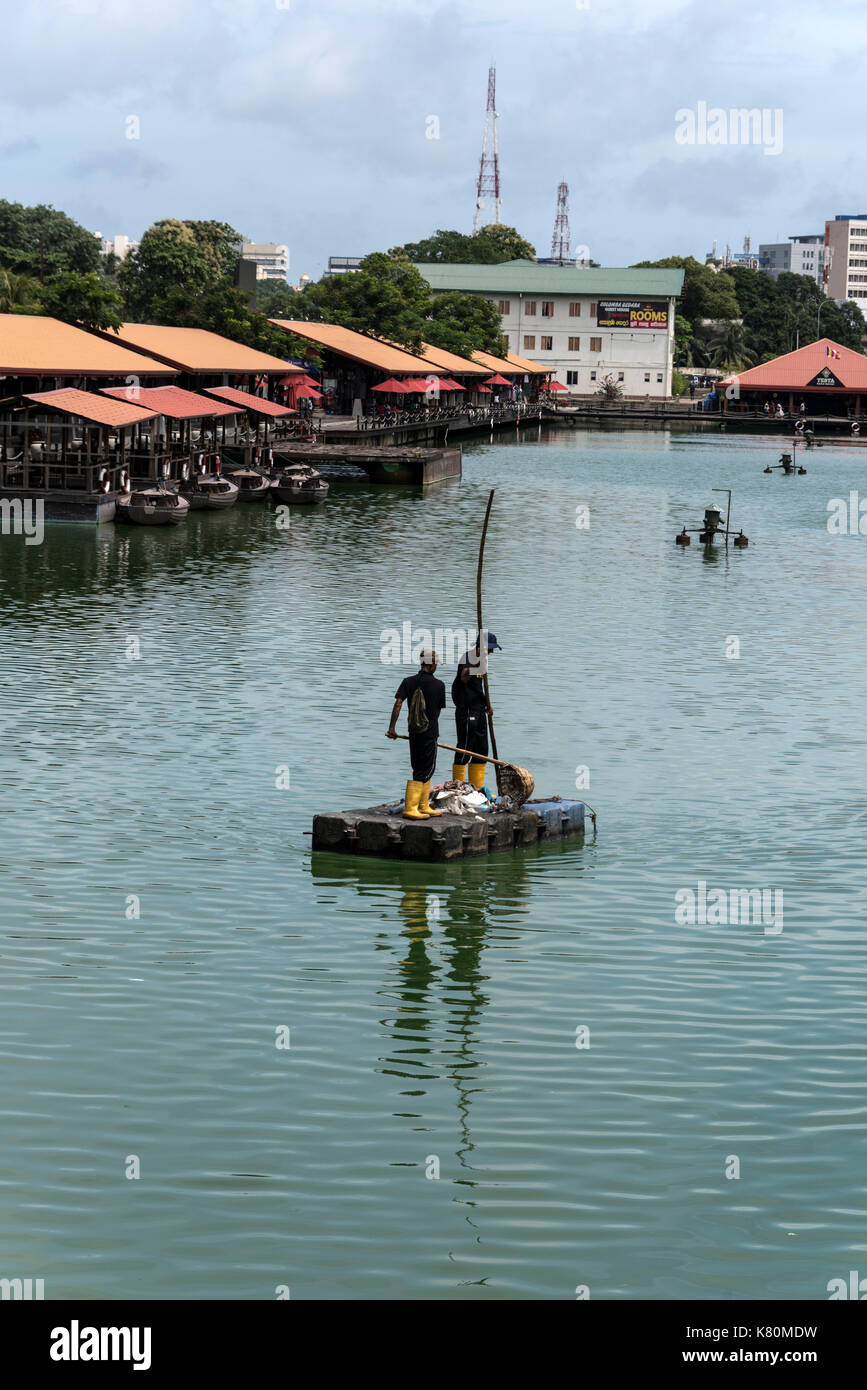 A couple of refuse collection workers on board their basic floating ...