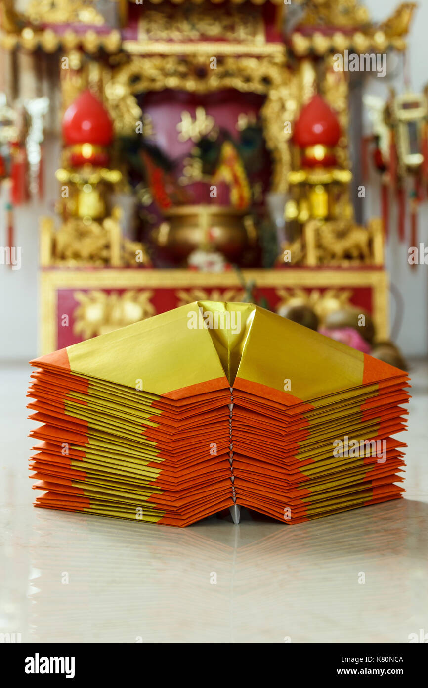 Chinese paper art use for worship.And a shrine in the background.Focus ...