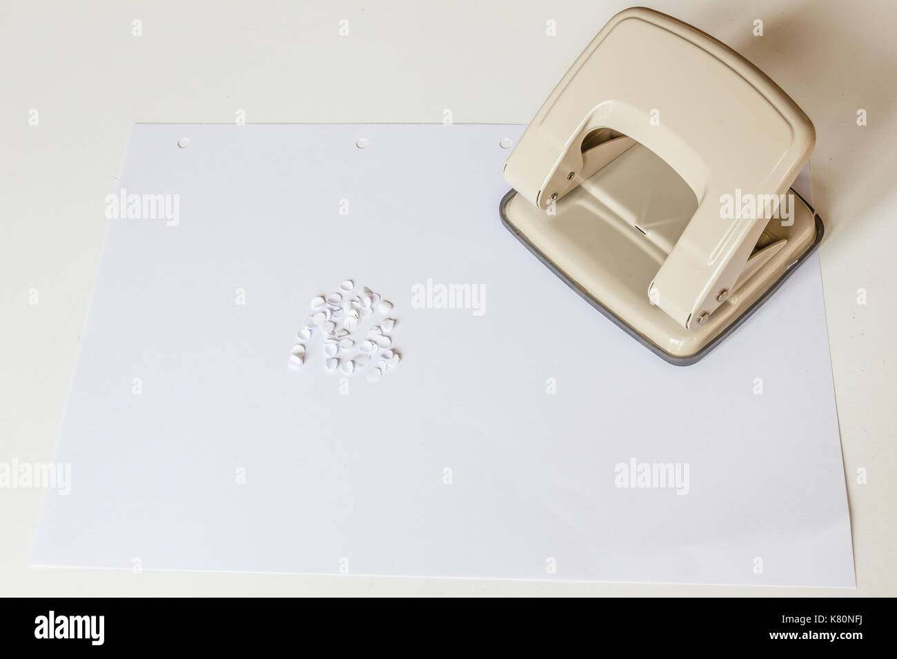 Punch (office accessory) with the paper Stock Photo - Alamy