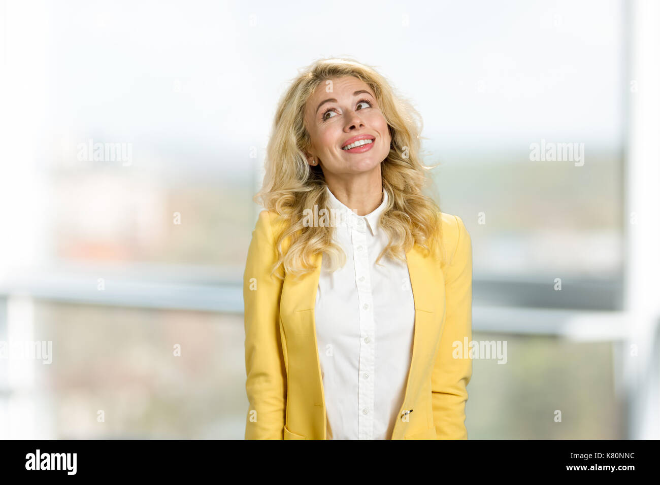 Cheerful young lady looking upwards Stock Photo - Alamy