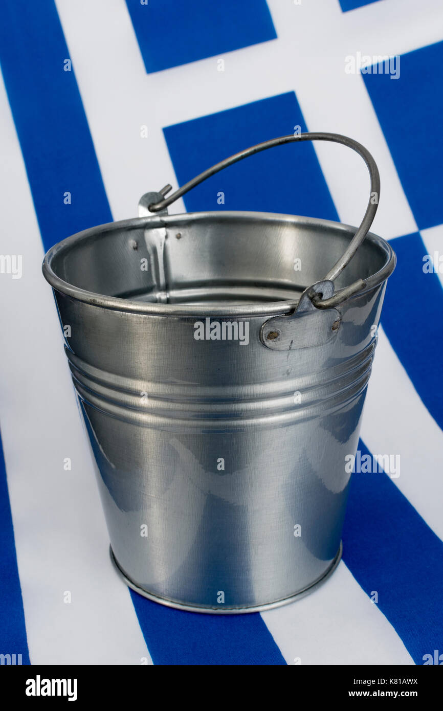 Greek flag with an empty metal bucket. For Greek financial crisis ...