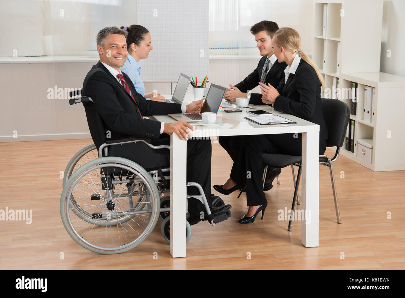 Happy Mature Disabled Businessman Having Meeting With Colleagues In ...
