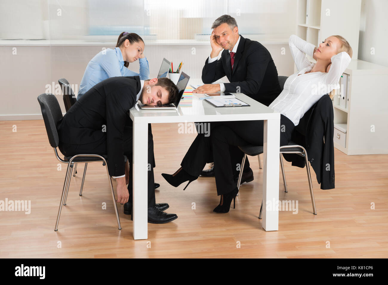 Businesspeople Getting Bored While Sitting At Desk In Office Stock ... Businesspeople Getting Bored While Sitting At Desk In Office Stock ...