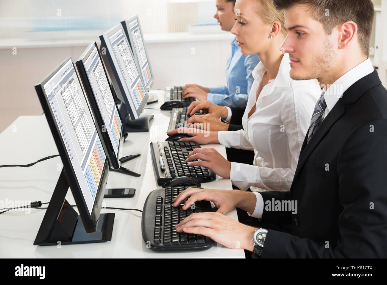 Group Of Young Businesspeople Working On Computer Stock Photo - Alamy