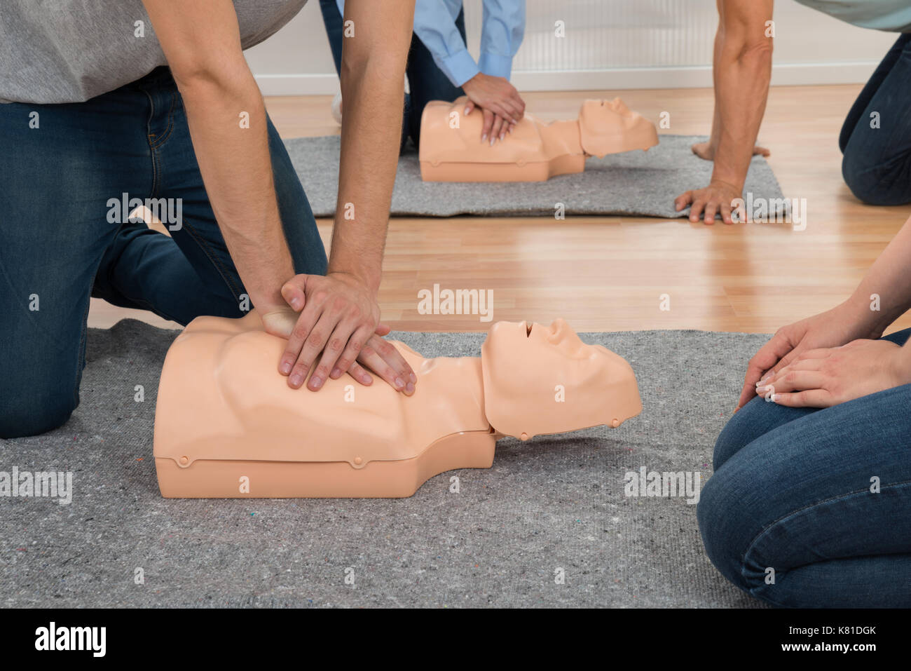 Students Practicing Cpr Chest Compression On Dummy In Class Stock Photo ...