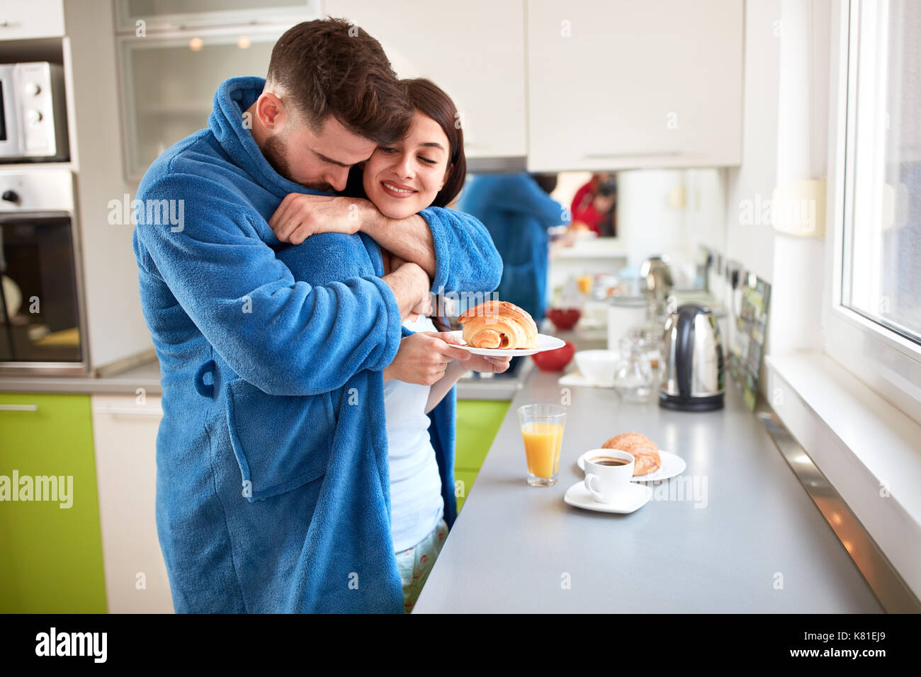 Young happy couple hugging in kitchen in the morning Stock Photo - Alamy