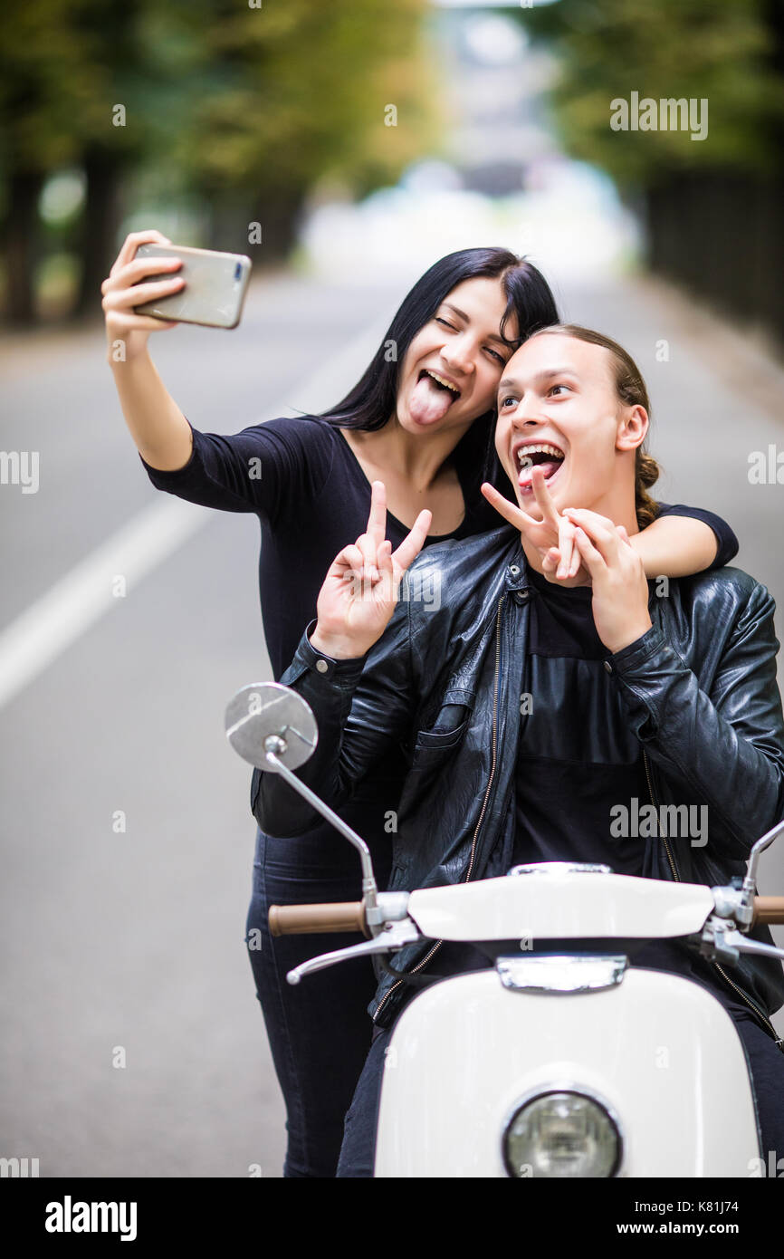 Selfie Beautiful young loving couple sitting on scooter together and ...