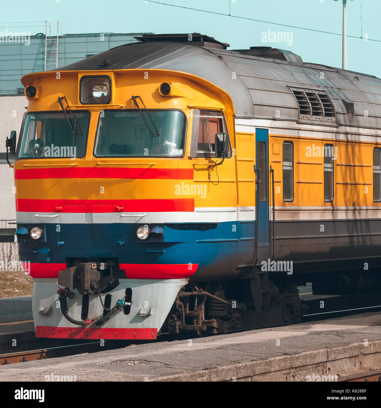 Old yellow passenger diesel train moving at the terminal Stock Photo ...