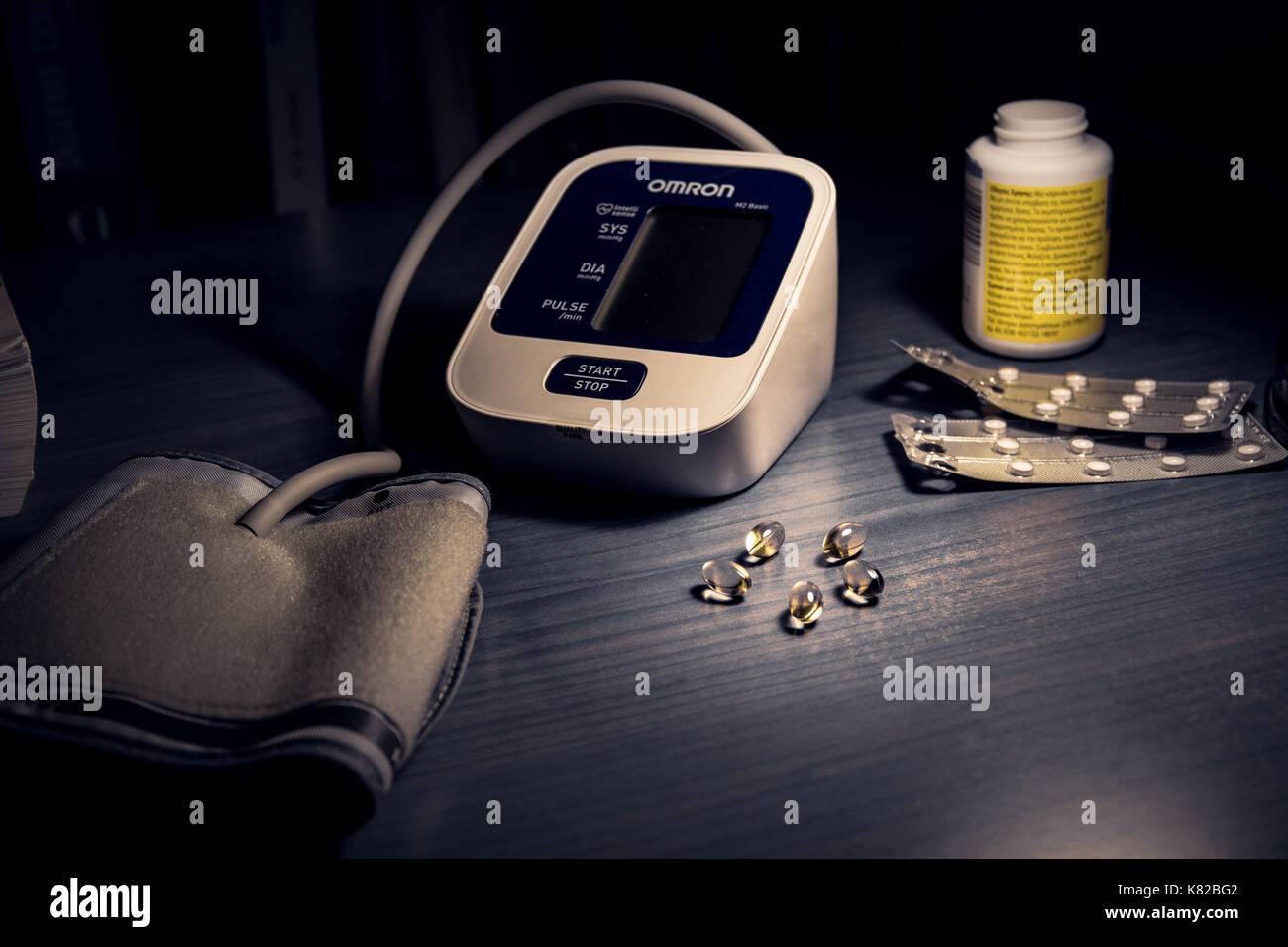 blood pressure monitor and pills on a desk Stock Photo - Alamy