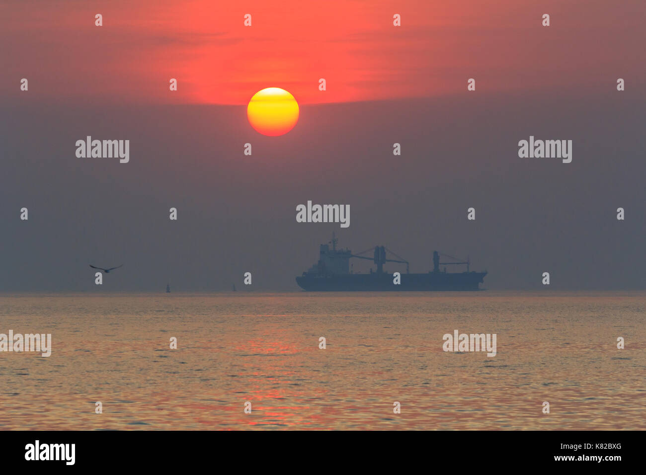 sunset at the sea with ferry boat Stock Photo - Alamy