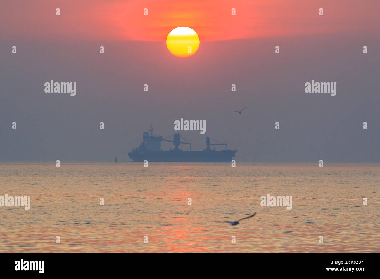 sunset at the sea with ferry boat Stock Photo - Alamy