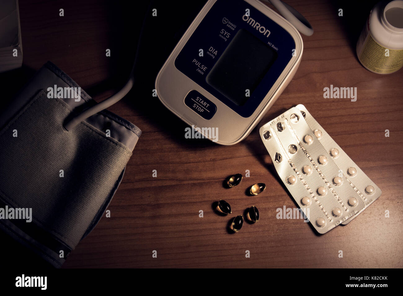 blood pressure monitor and pills on a desk Stock Photo - Alamy