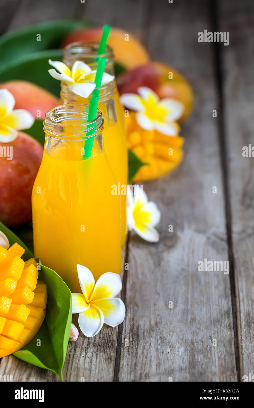 Fresh mango juice in small bottles. Copyspace background Stock Photo ...