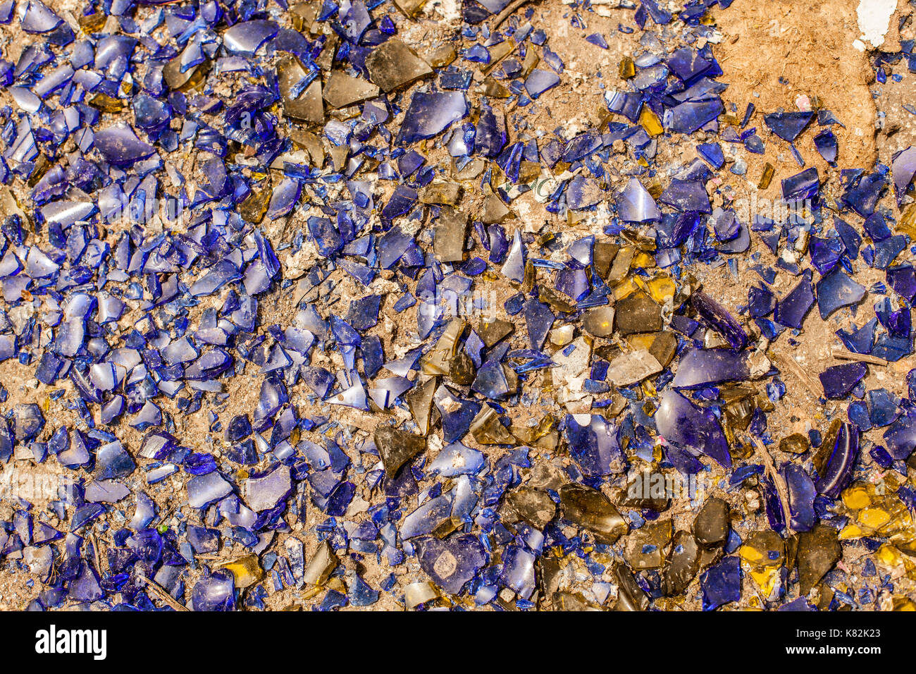 many broken pieces of glass in blue on the ground. Cracked blue glass ...