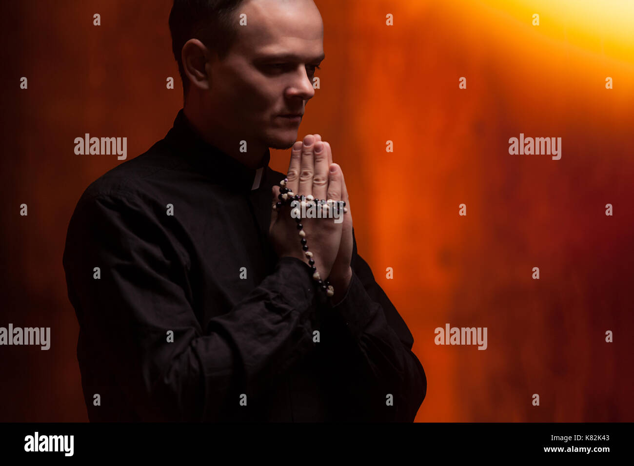 Portrait of handsome catholic priest or pastor with dog collar, dark ...