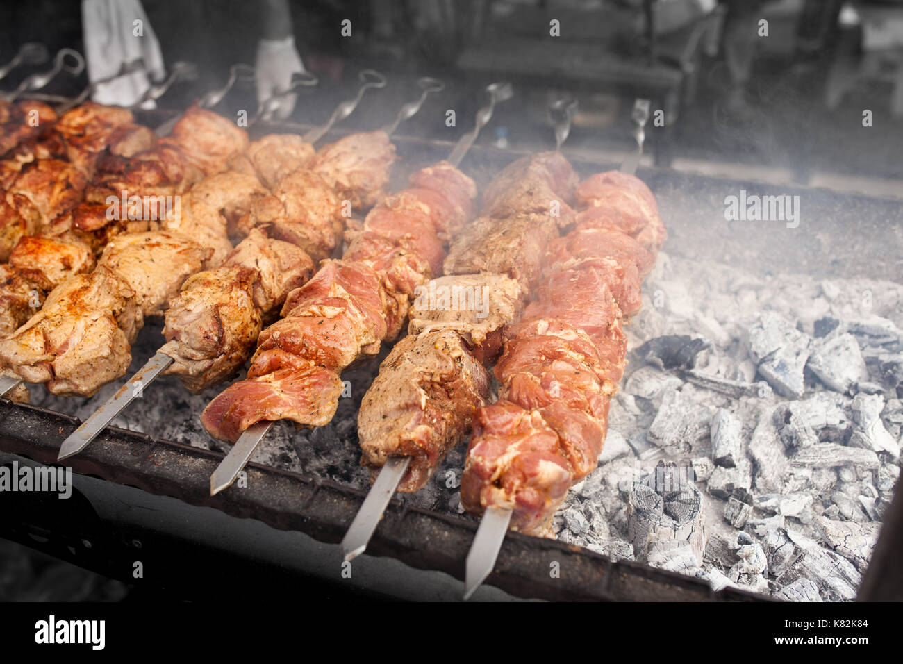Grilled kebab cooking on metal skewer. Roasted meat cooked at barbecue ...