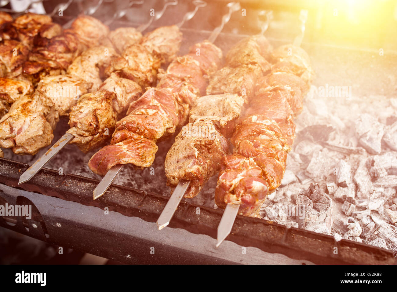 Grilled kebab cooking on metal skewer. Roasted meat cooked at barbecue ...