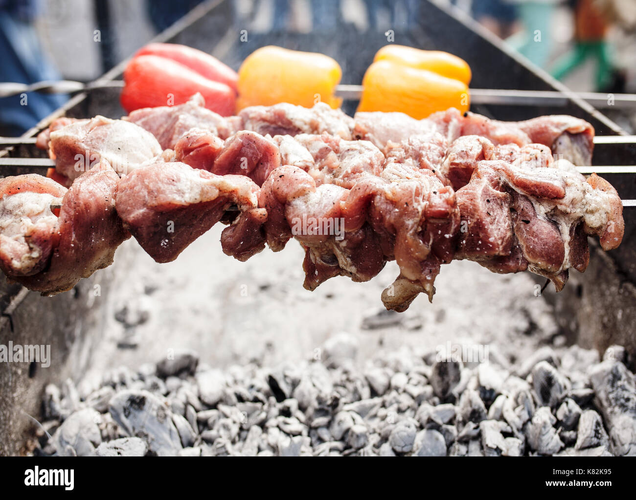 Grilled kebab cooking on metal skewer. Roasted meat cooked at barbecue ...