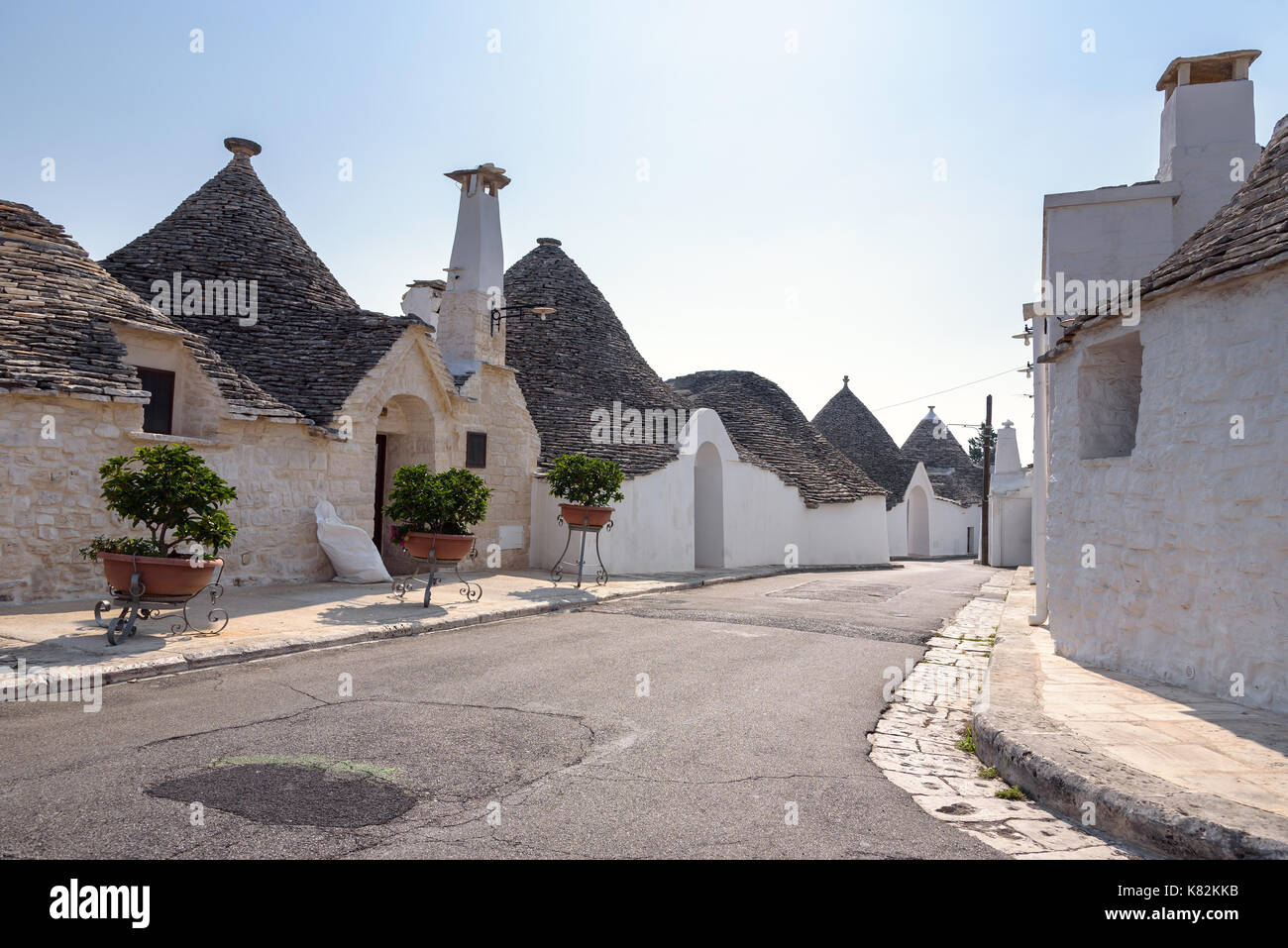 View of street in Alberobello town with famous trulli houses, Italy ...