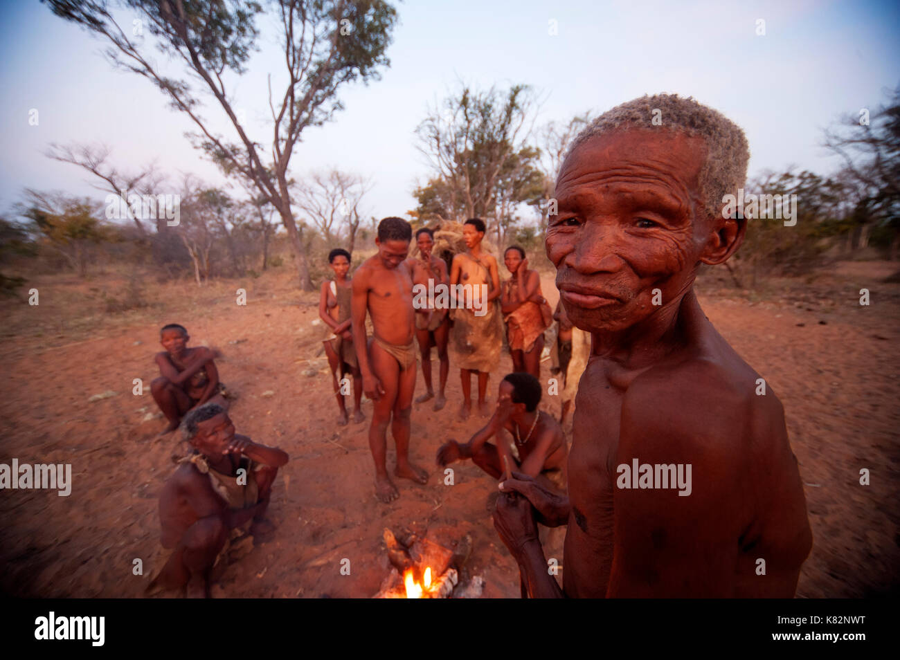 Ju/'Hoansi or San bushmen hunter gathering around camp fire at their ...