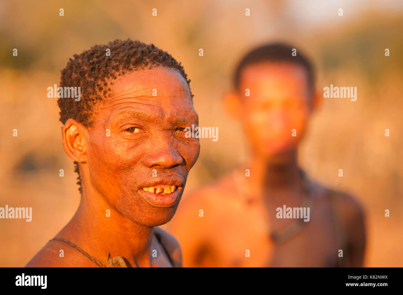 Ju/'Hoansi or San bushmen hunter gathering around camp fire at their ...