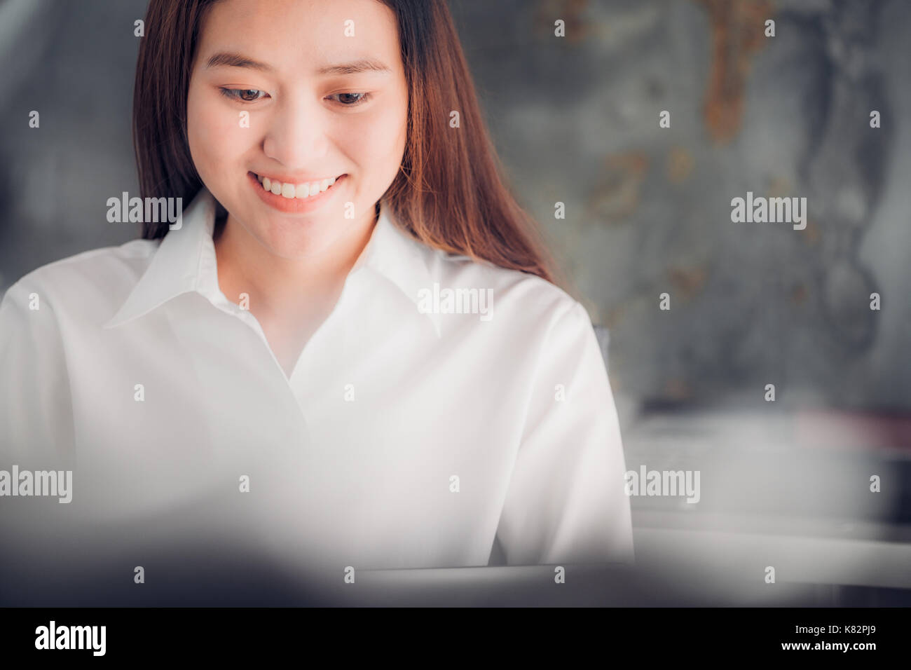 Asian businesswoman looking at laptop computer and smiling face with ...