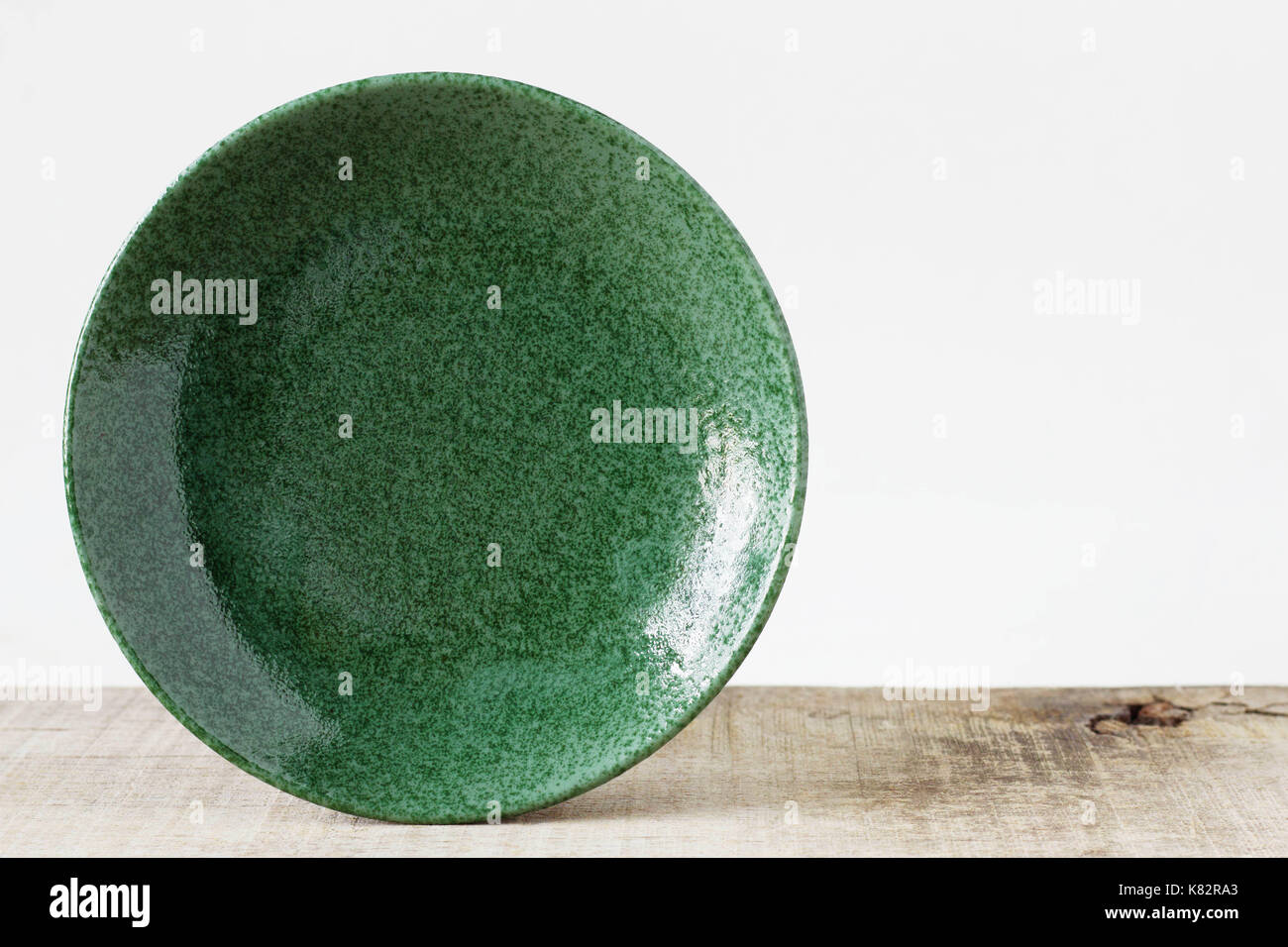 Green plate on wooden with a white background Stock Photo - Alamy