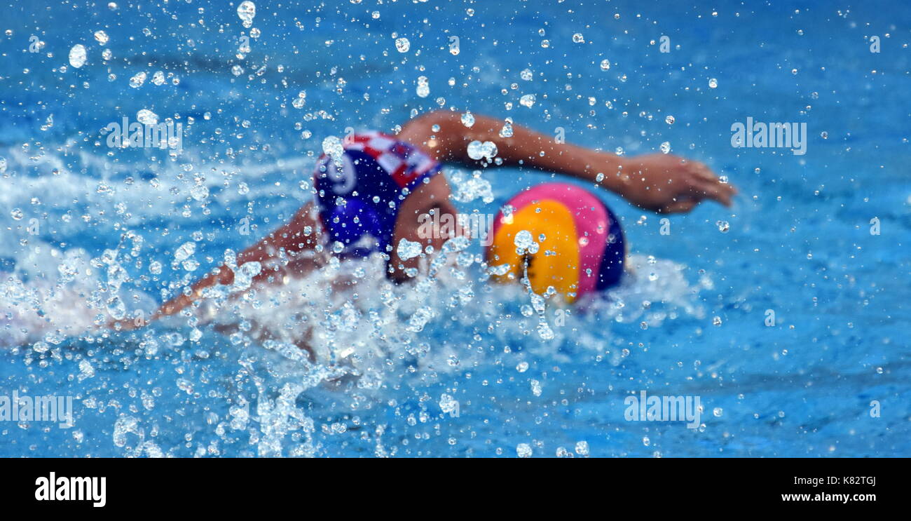 Splash of water, waterdrops are in focus. Waterpolo player swimming ...