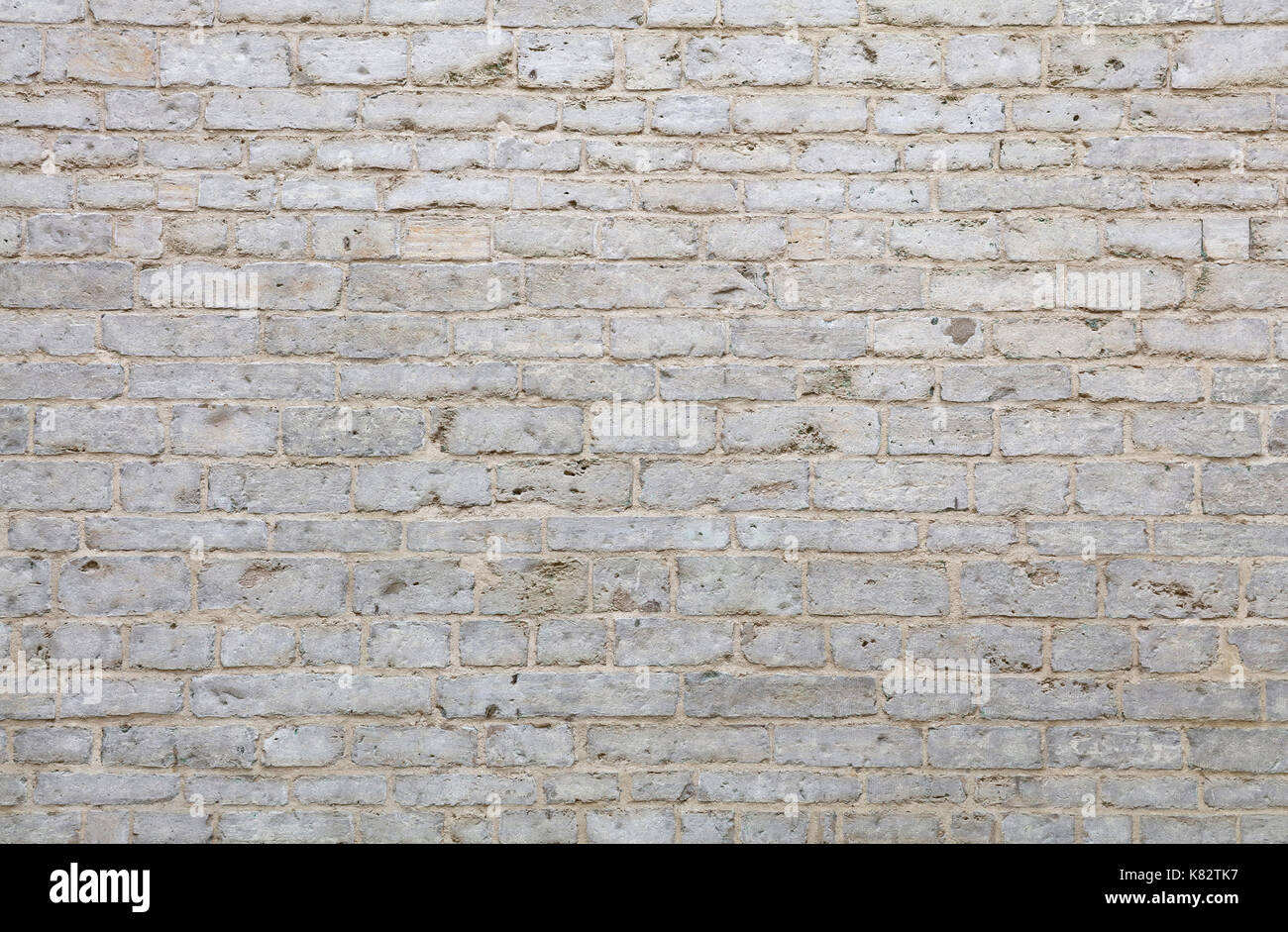 Wall of white and gray weathered limestone travertine stone brick ...