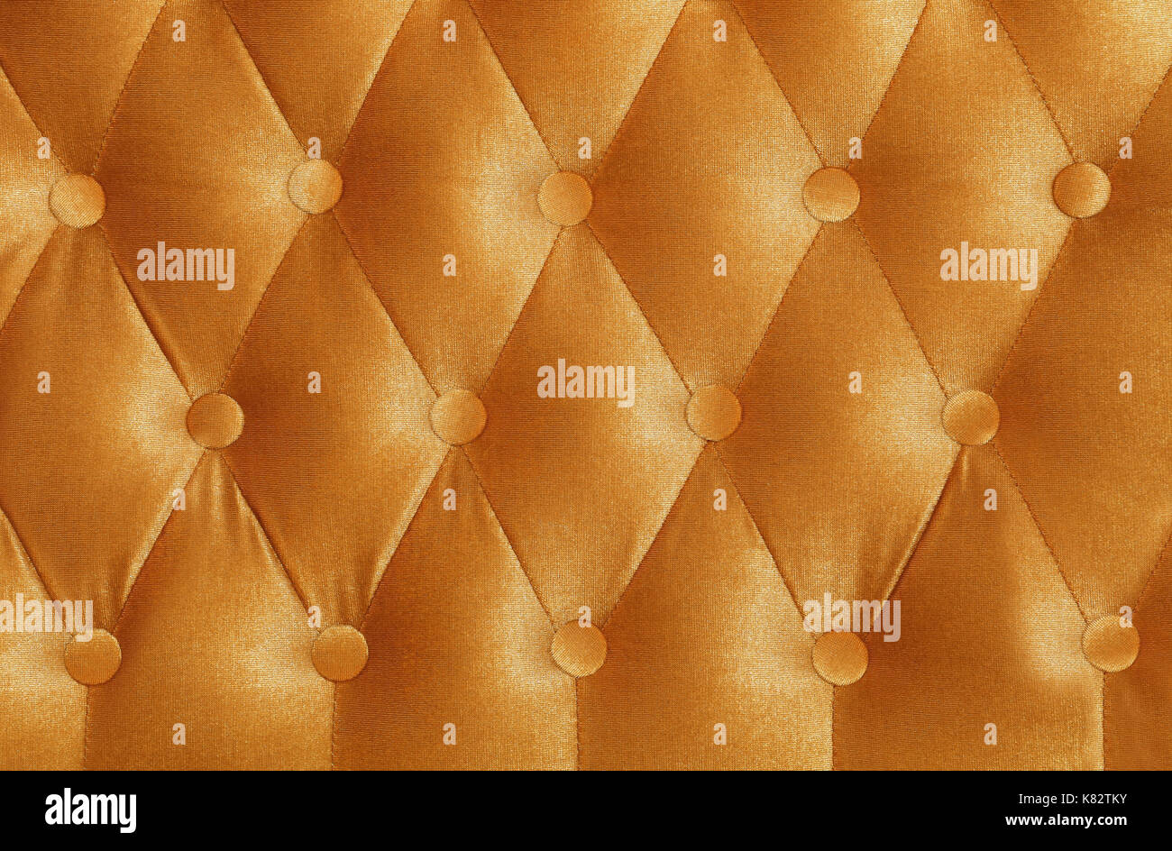 Golden orange color capitone textile background with buttons, retro ...