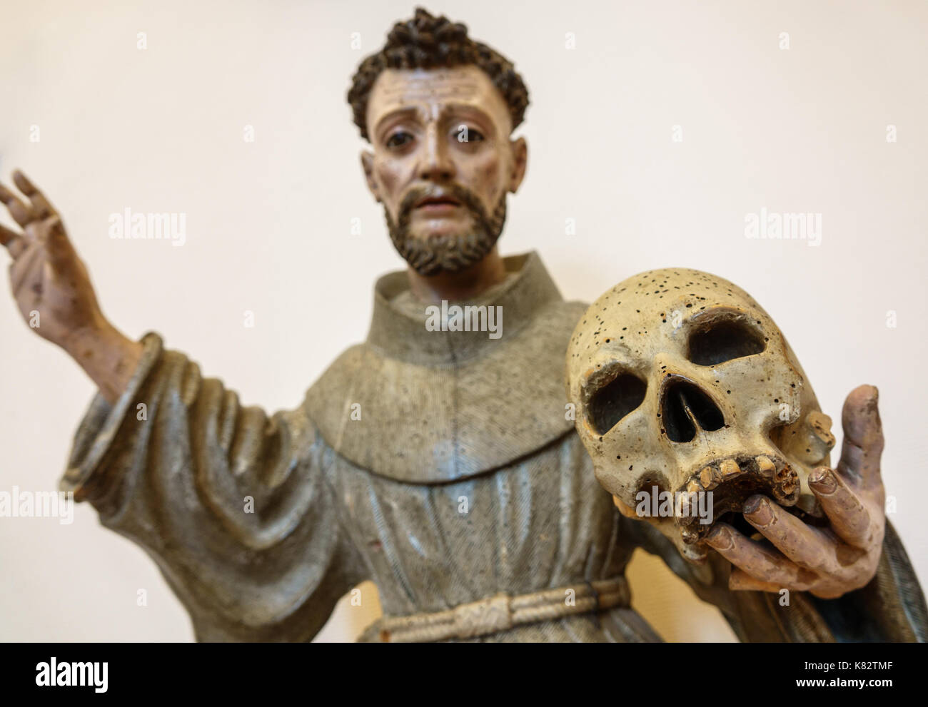 Wooden holy figure holding skull with woodworm Stock Photo - Alamy