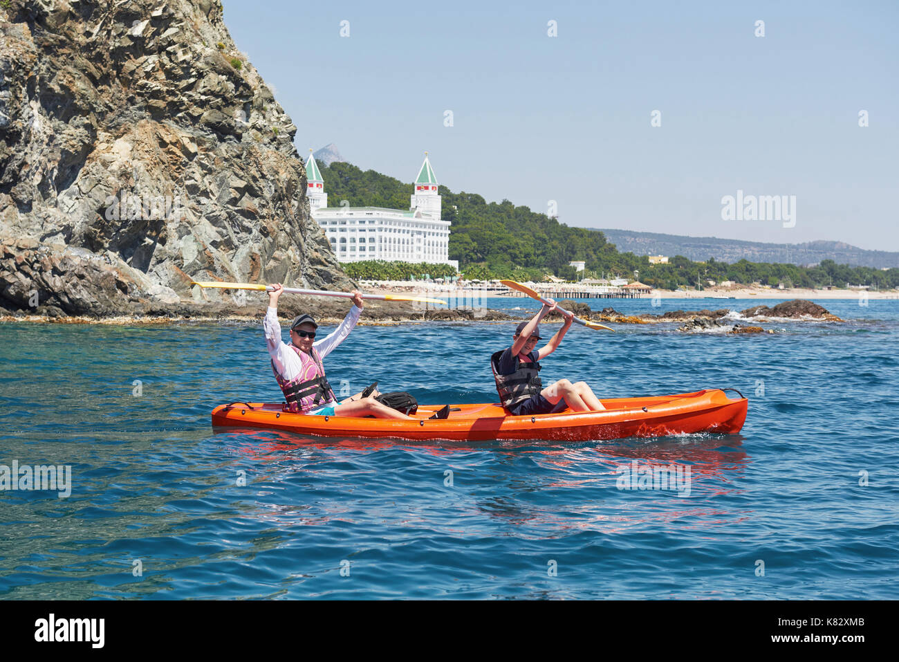 Boat kayaking near cliffs on a sunny day. Kayaking in a quiet bay ...