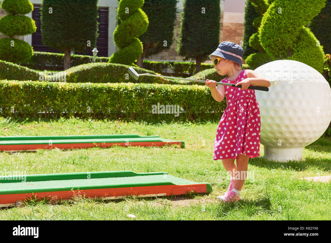 Child playing mini - golf on artificial grass Stock Photo - Alamy