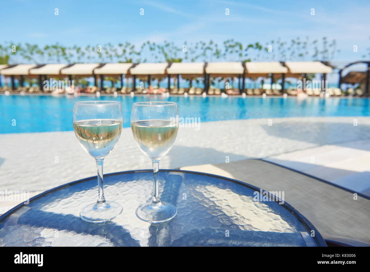 Glasses of champagne at a resort pool in a luxury hotel. Party by the ...