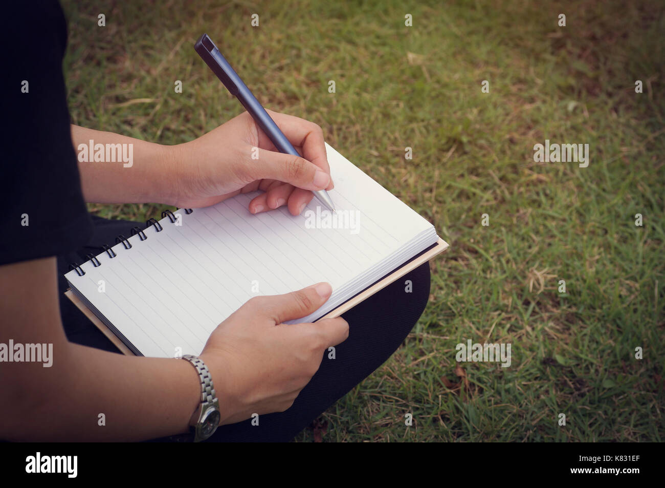 young girl 's hand writing on diary at filed Stock Photo - Alamy