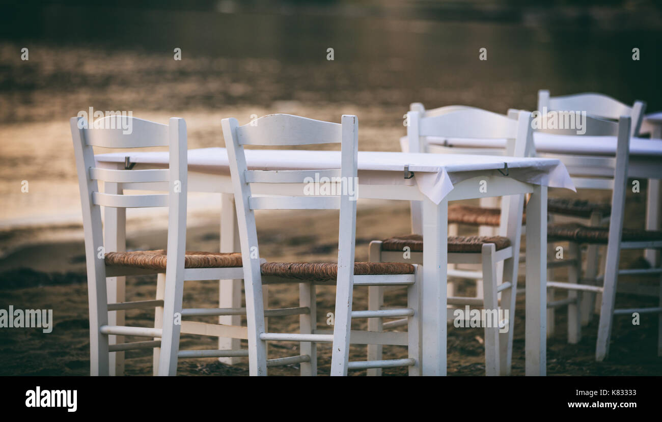 White Greek tavern tables by the sea Stock Photo - Alamy