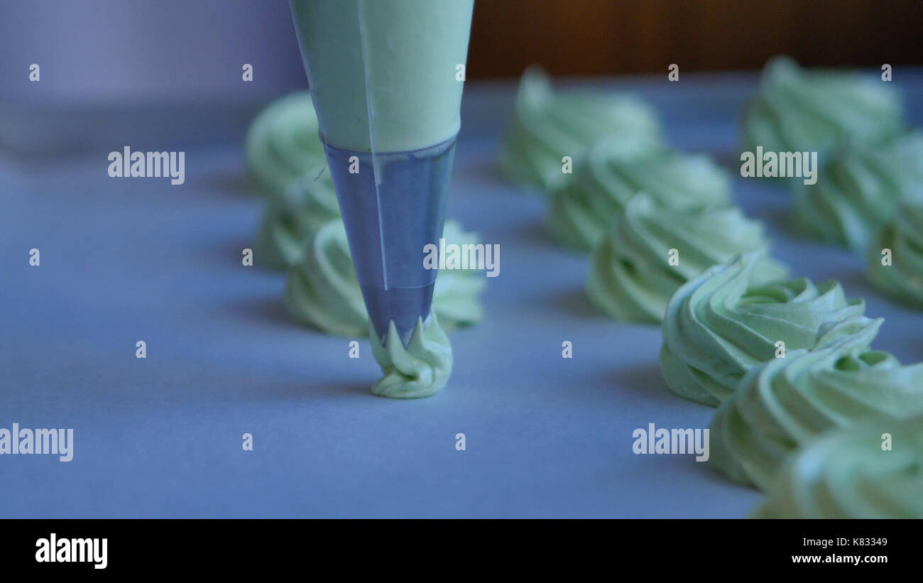 Squeeze the cream filling on the green cupcake, closeup Stock Photo - Alamy