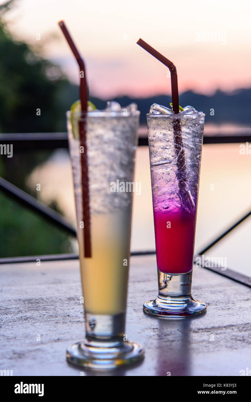 cocktail in the glass with sunset view / beverage with sunset at the ...