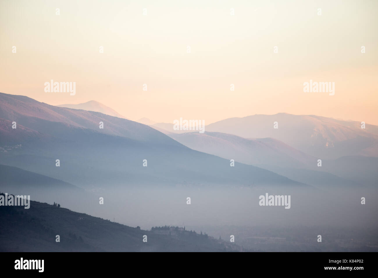 A valley filled by mist at sunset, with emerging trees and towns Stock ...