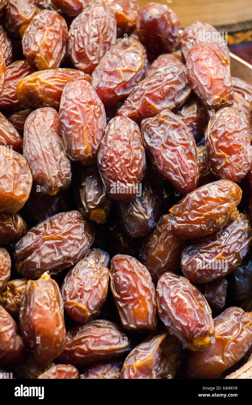 hand holding dates on a linen canvas background Stock Photo - Alamy