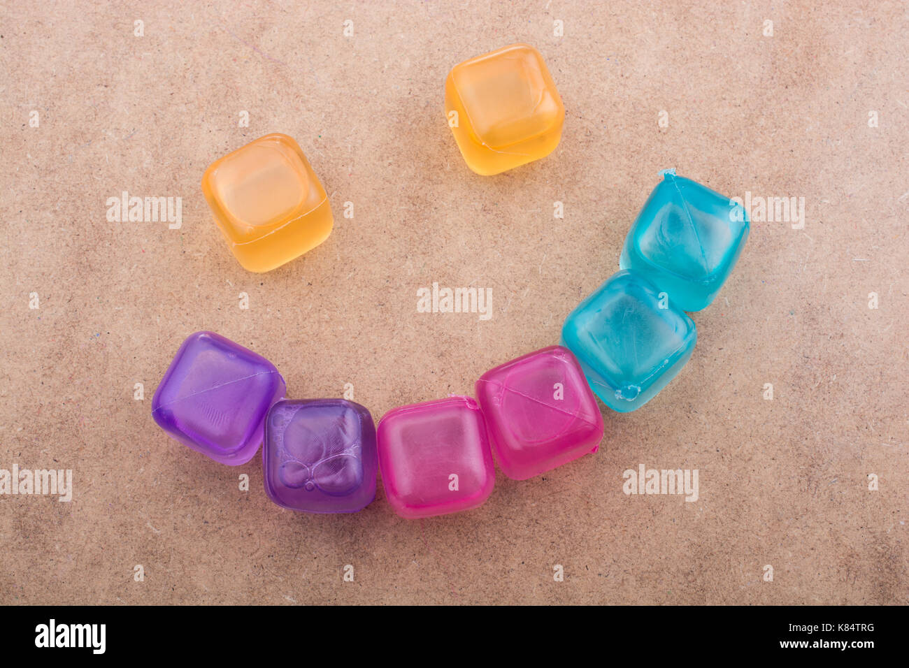 Fake colorful ice cubes on a brown background Stock Photo - Alamy
