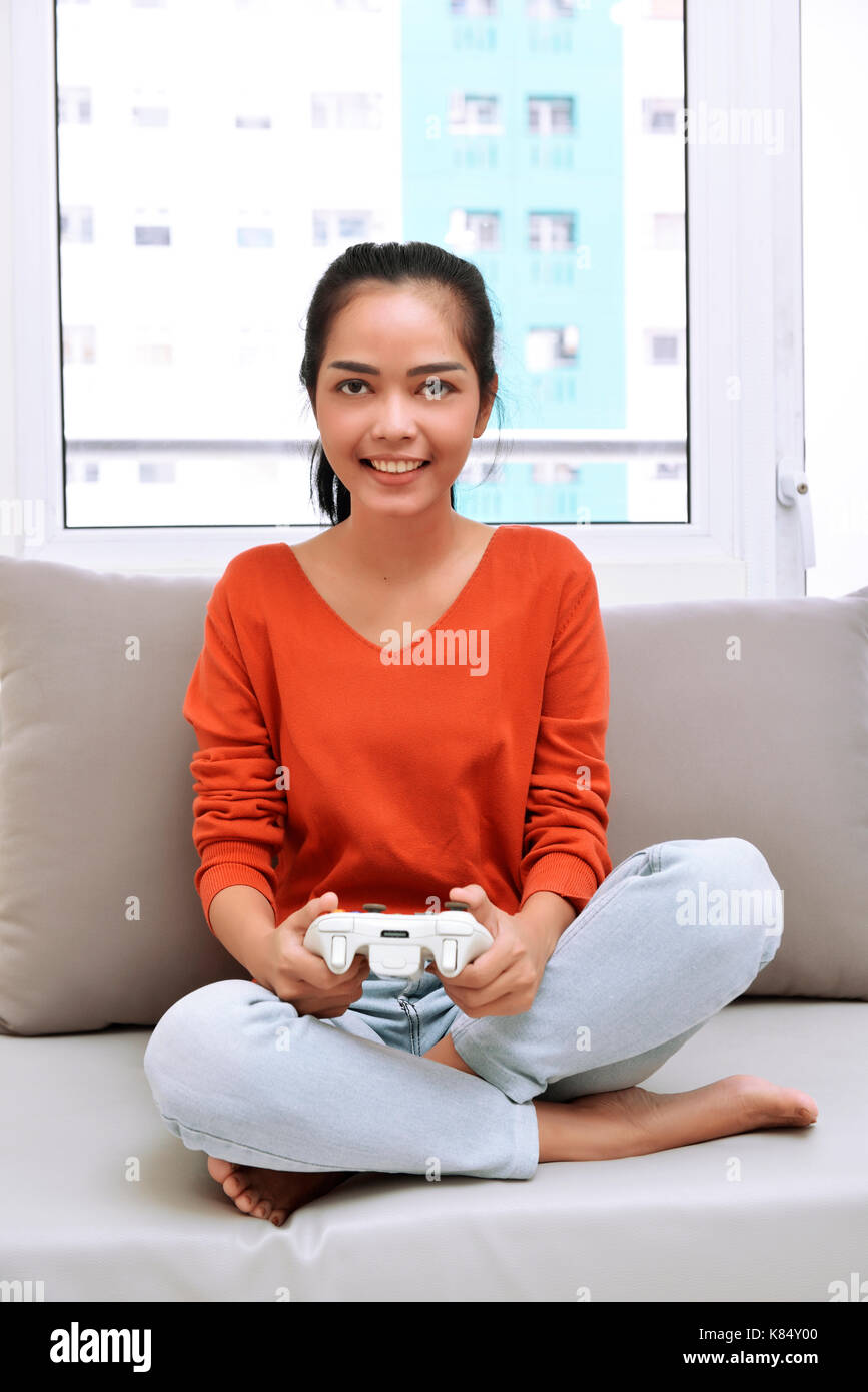 Happy asian woman with gamepad playing video games at home Stock Photo ...