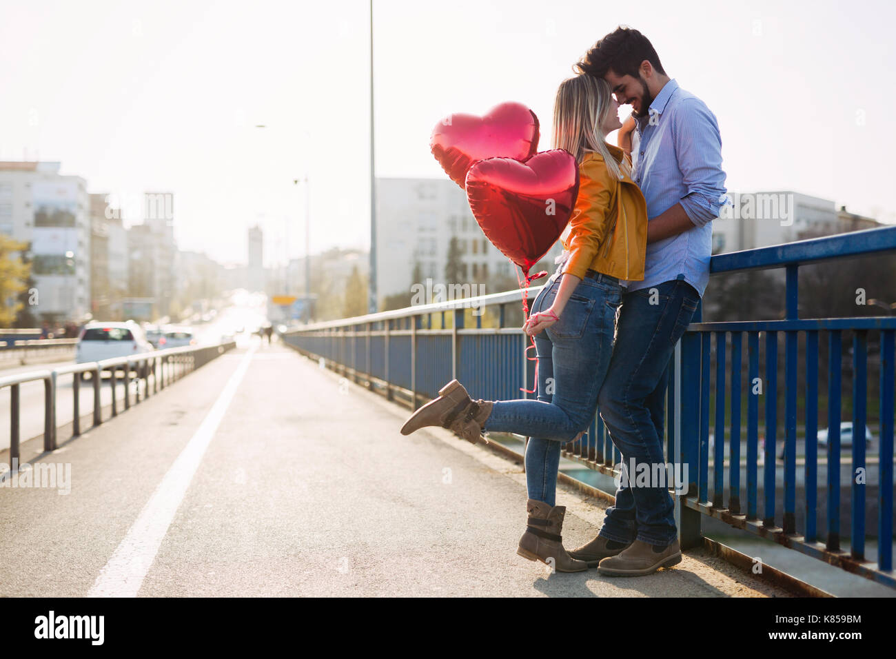 Couple in love cuddling while enjoying beautiful urban sunset together ...