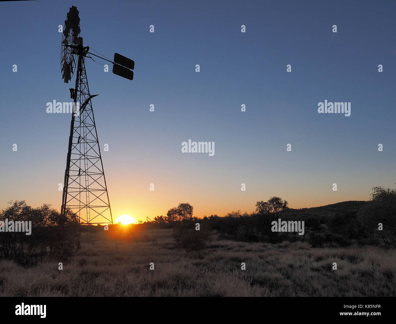 Windmill in front of sunset sky, part of a water well, Northern ...