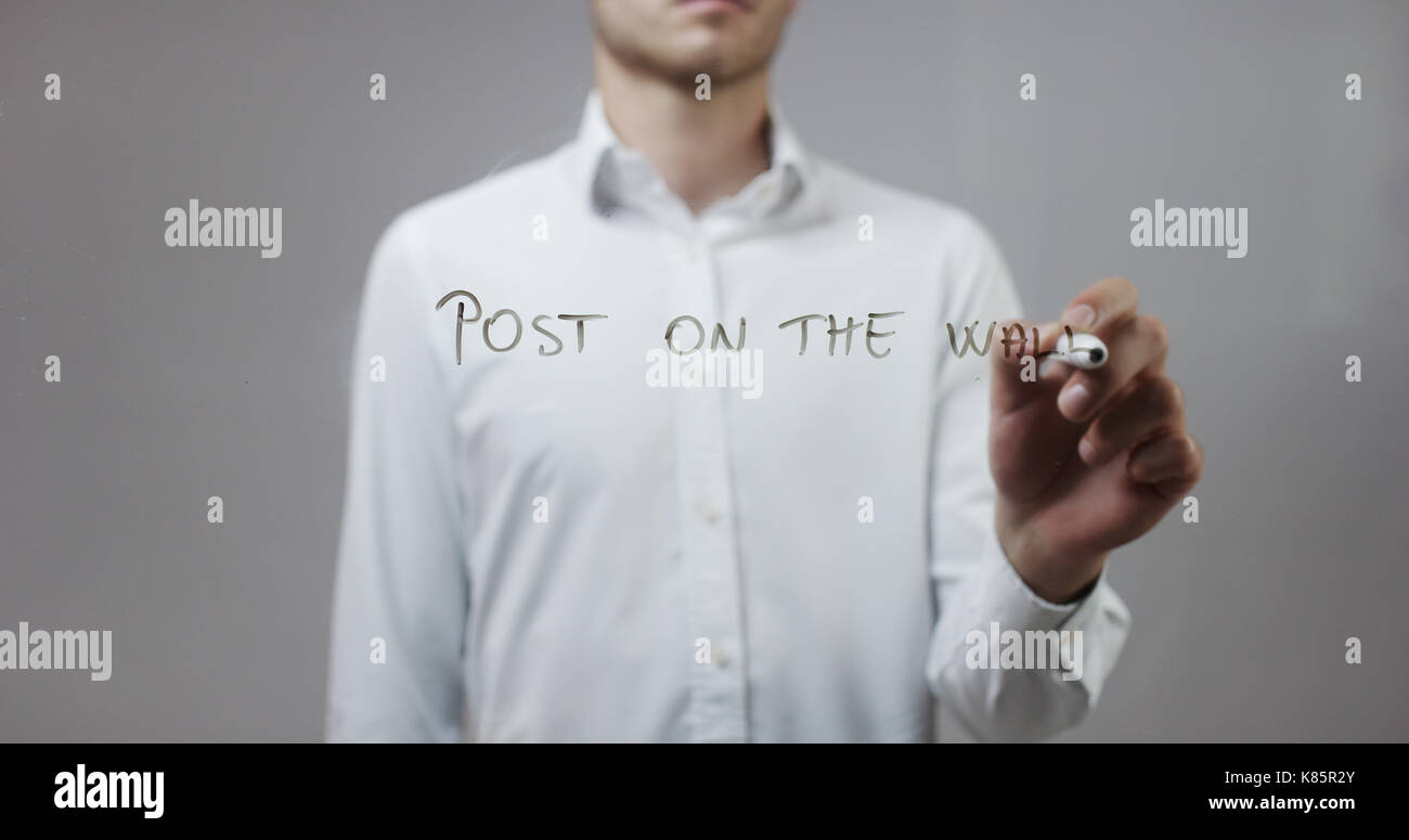 Post on the wall, Man Writing on Glass Stock Photo - Alamy