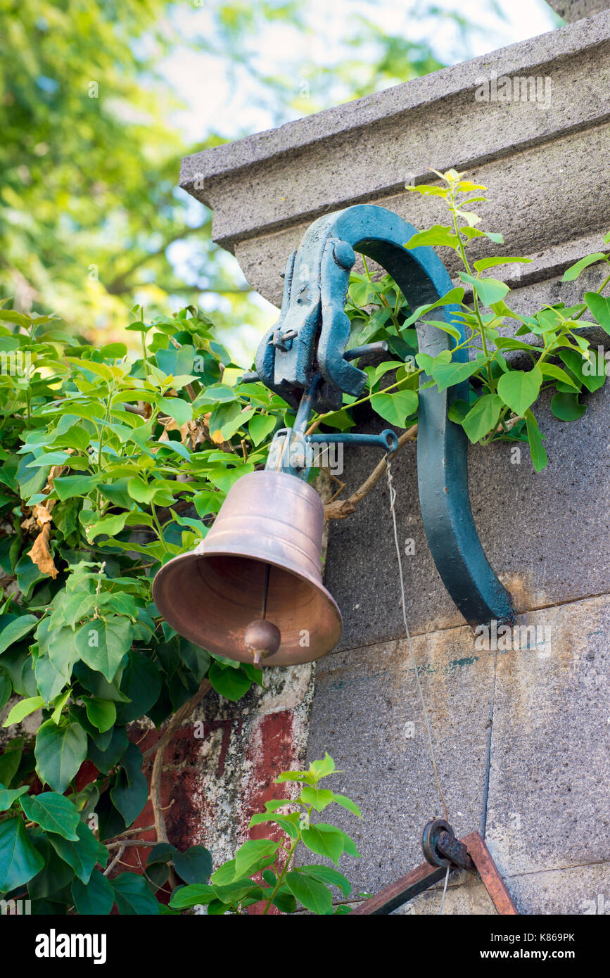 small bronze bell on a stone wall Stock Photo - Alamy