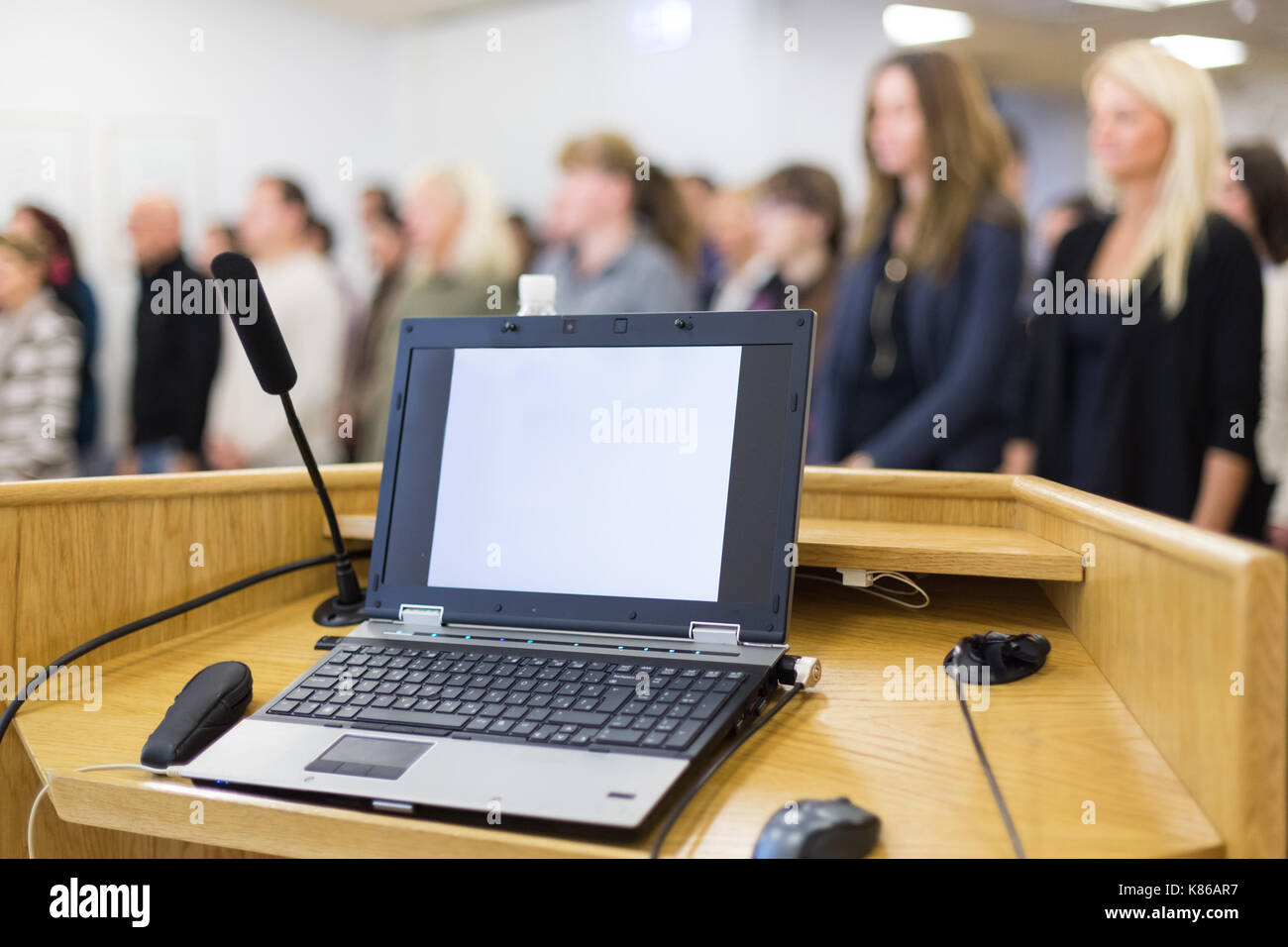 Laptop computer and microphotone at podium on business conference event ...