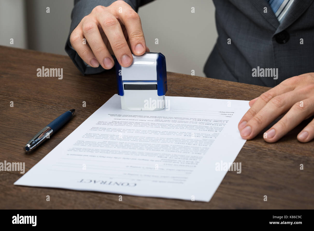 Close-up Of Businessman Stamping Document At Desk In Office Stock Photo ...