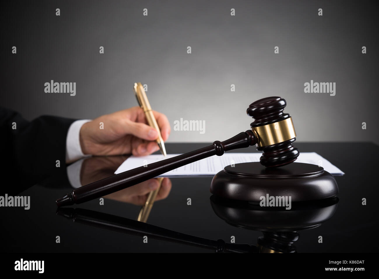 Close-up Of Judge Hands Writing On Paper With Pen And Gavel In ...